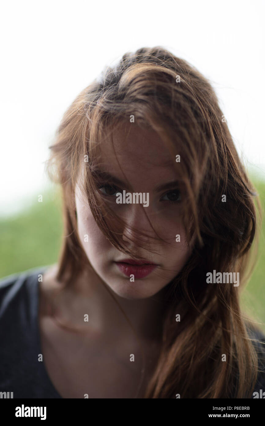 Female model staring seductively at the camera with hair fallen on her ...