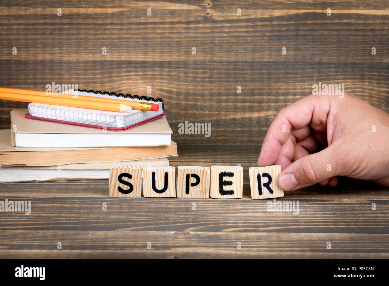 Super. Wooden letters on the office desk Stock Photo - Alamy