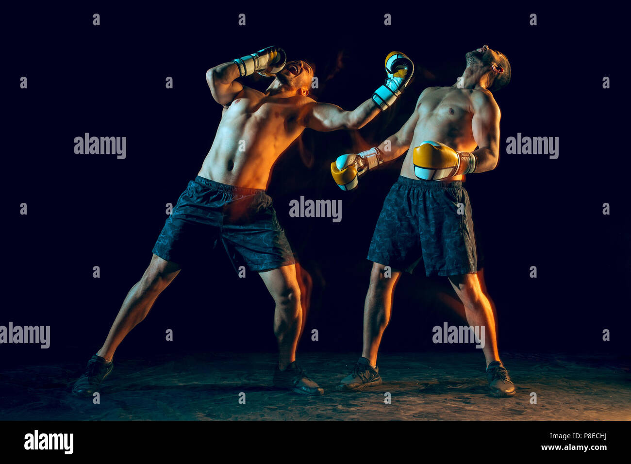 Male boxer boxing in a dark studio Stock Photo - Alamy