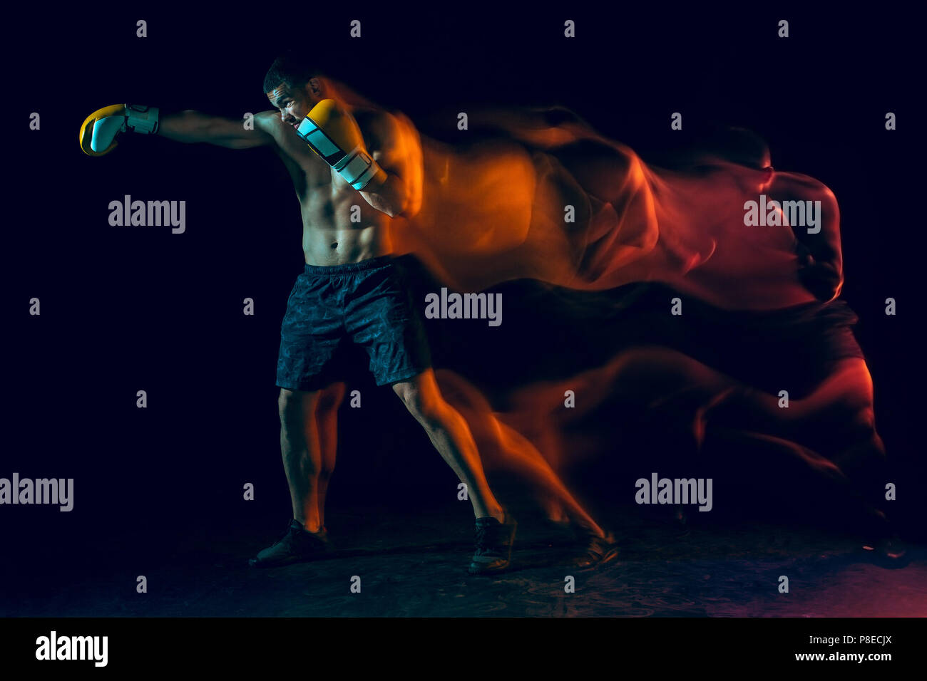 Male boxer boxing in a dark studio Stock Photo - Alamy