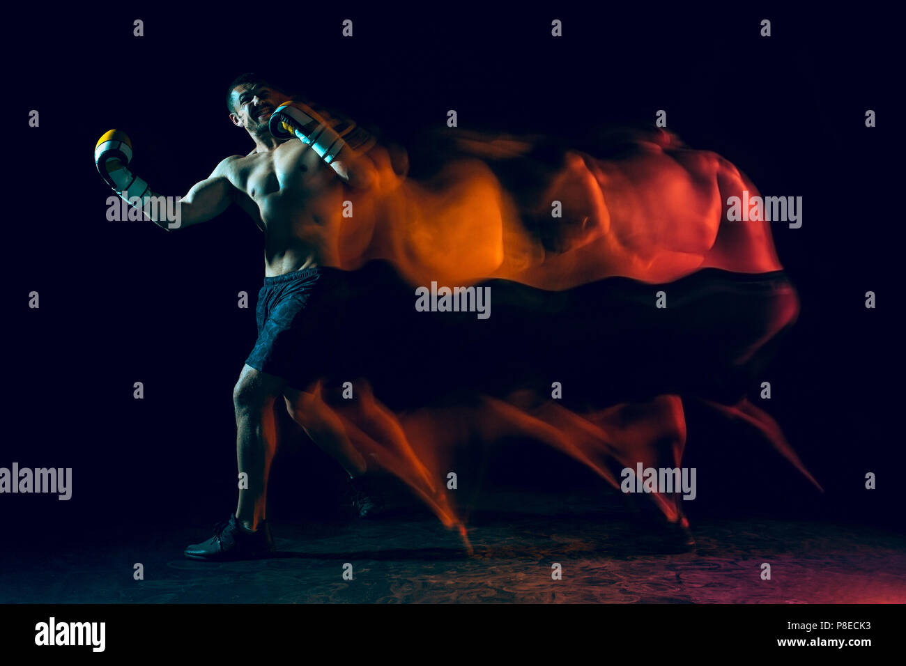 Male boxer boxing in a dark studio Stock Photo - Alamy
