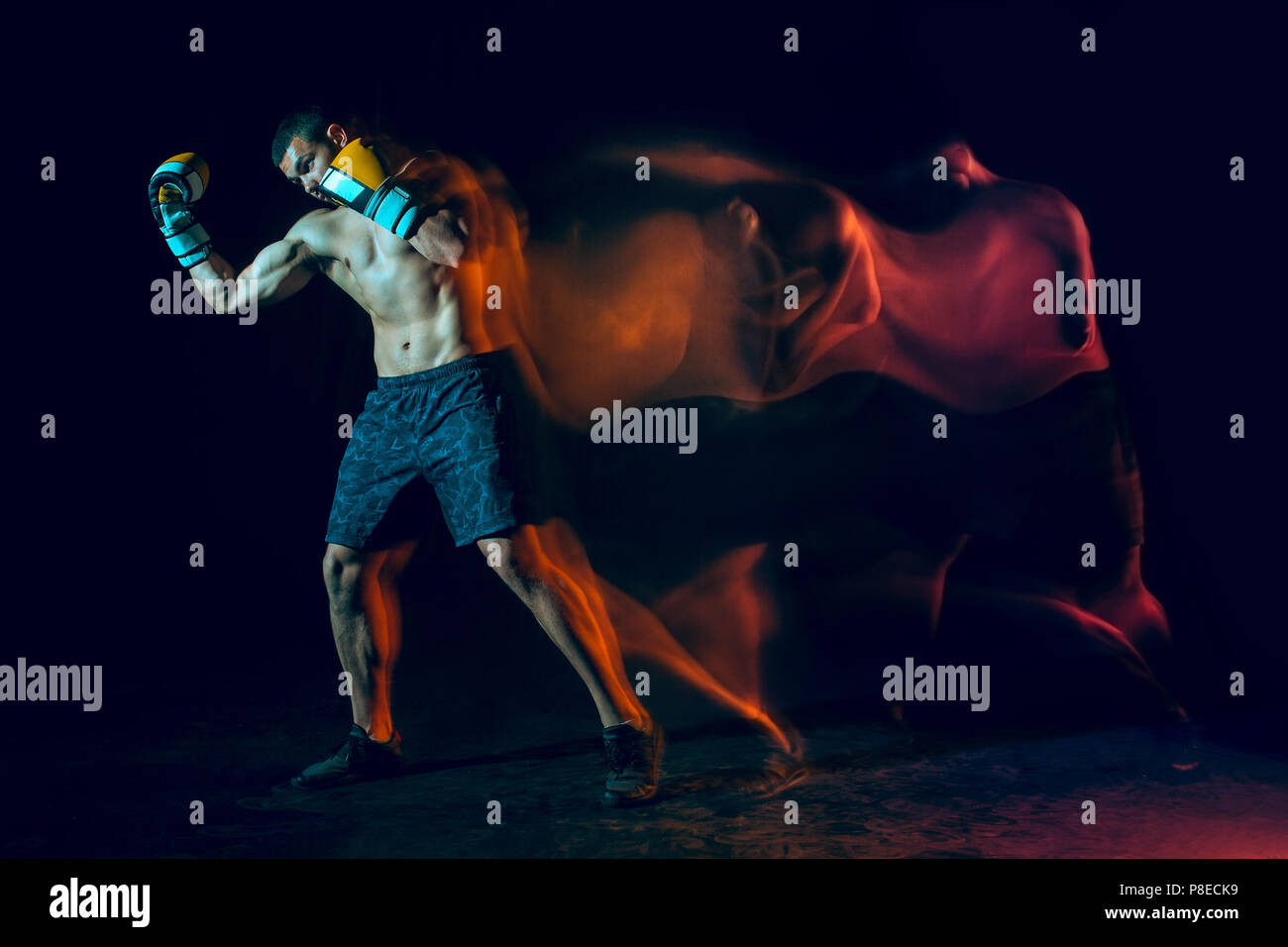 Male boxer boxing in a dark studio Stock Photo - Alamy