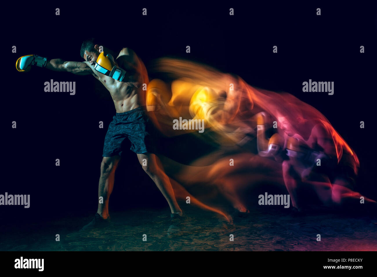 Male boxer boxing in a dark studio Stock Photo - Alamy