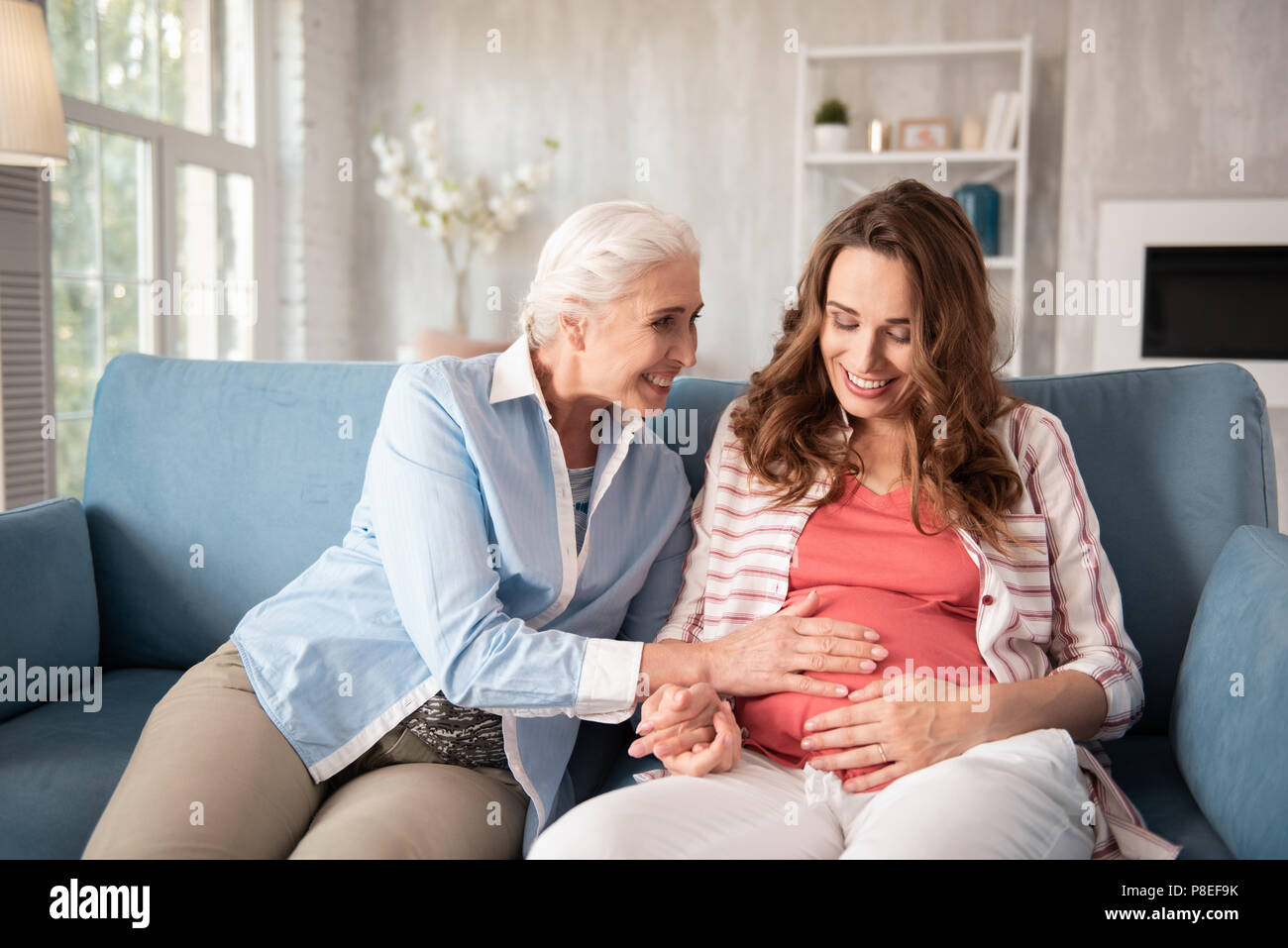 Kind-hearted mother coming for visiting her pregnant daughter Stock ...
