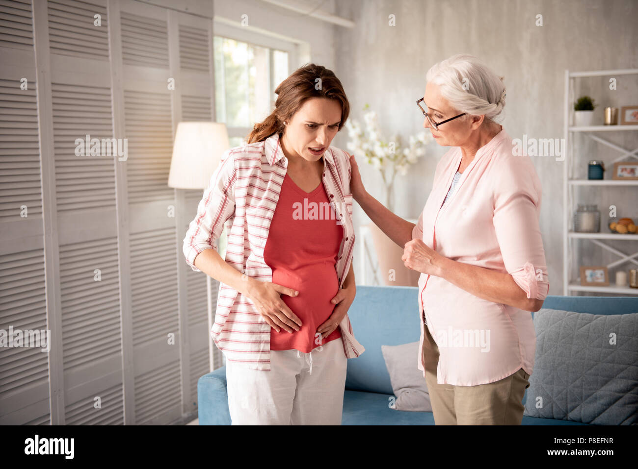 Pregnant woman feeling unexpected pain in her tummy Stock Photo - Alamy