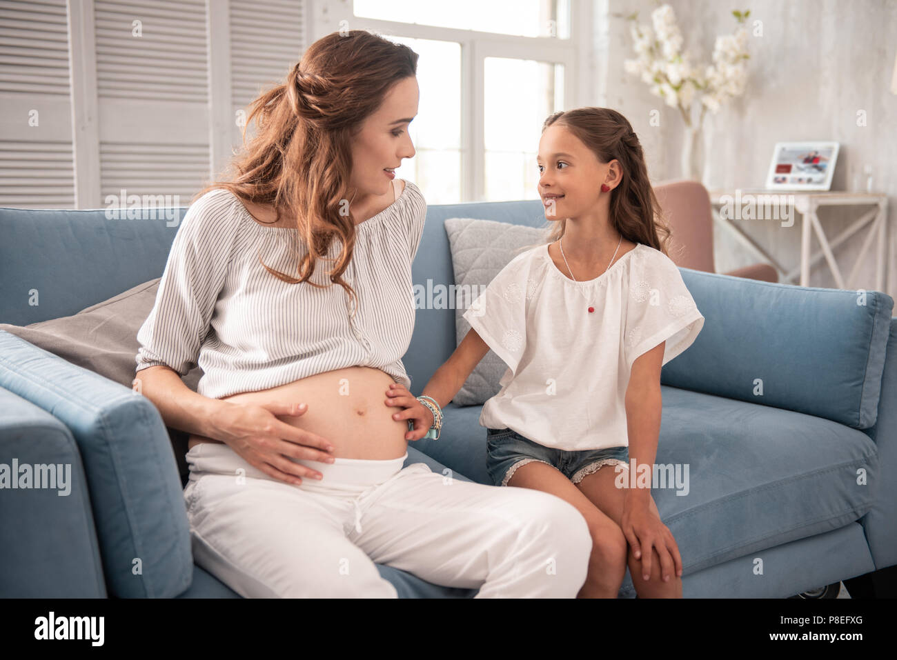 Little cute daughter coming to her pregnant mother Stock Photo - Alamy