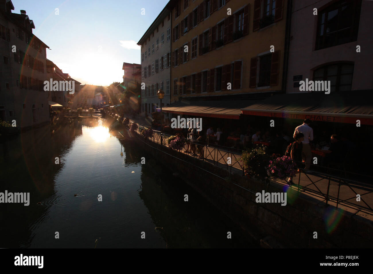 Crowds of tourists streaming next to the embanked river Thiou through ...