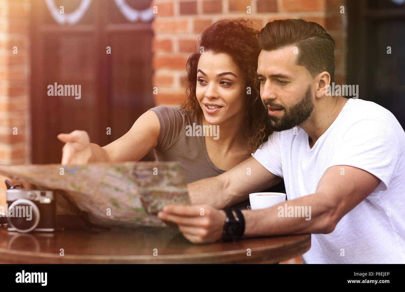 Young tourists having coffee at cafe and reading map Stock Photo - Alamy