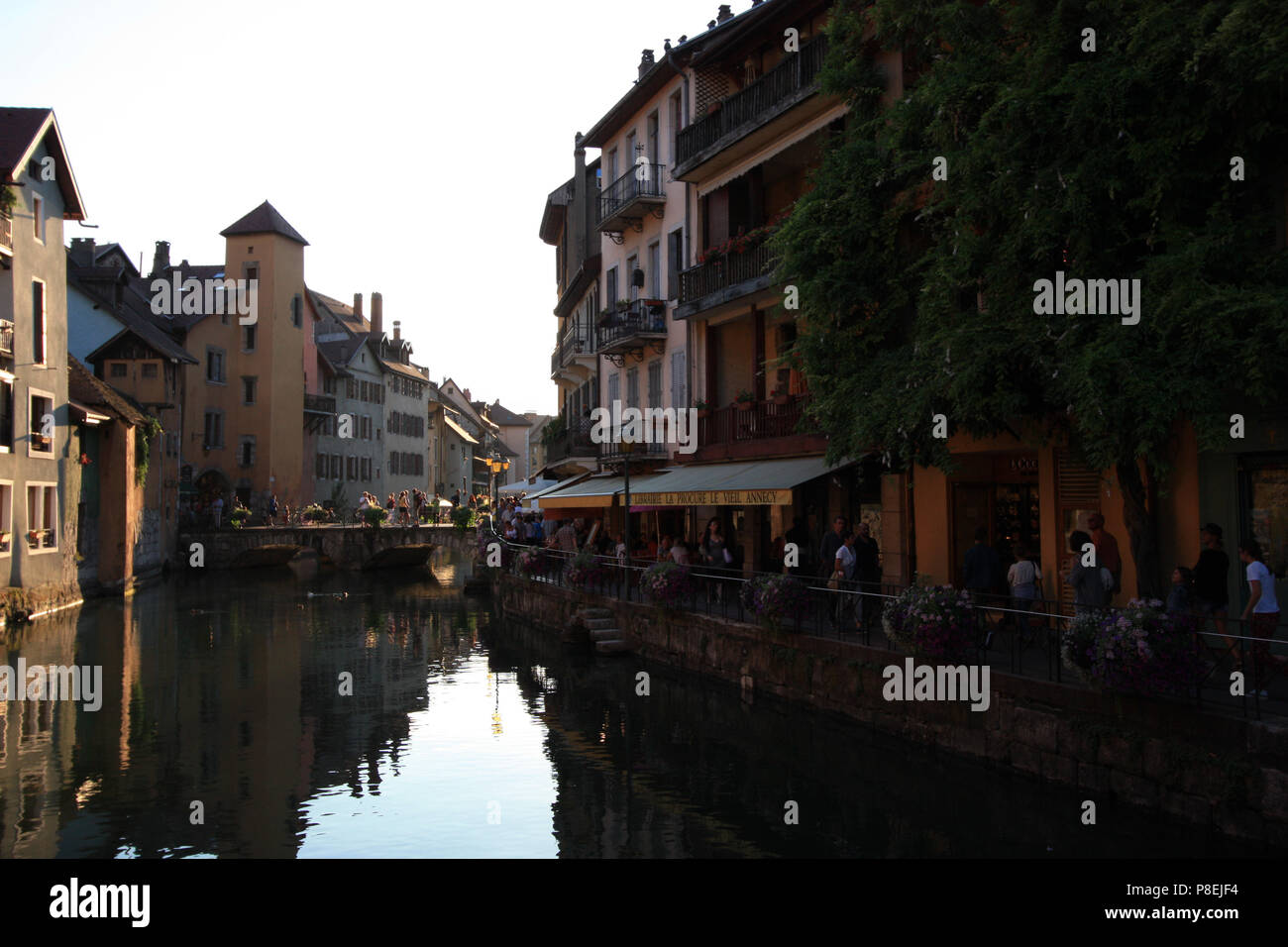 Crowds of tourists streaming next to the embanked river Thiou through ...