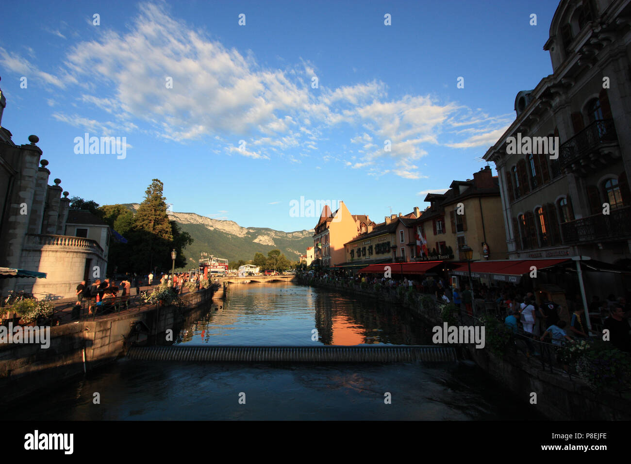 Crowds of tourists streaming next to the embanked river Thiou through ...