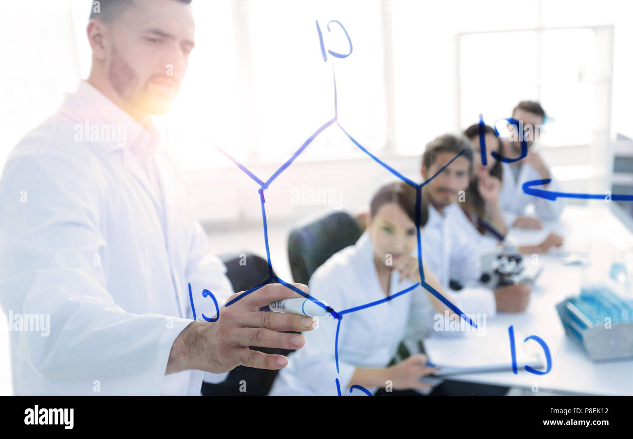 from behind the glass. a scientist standing near the blackboard in the ...