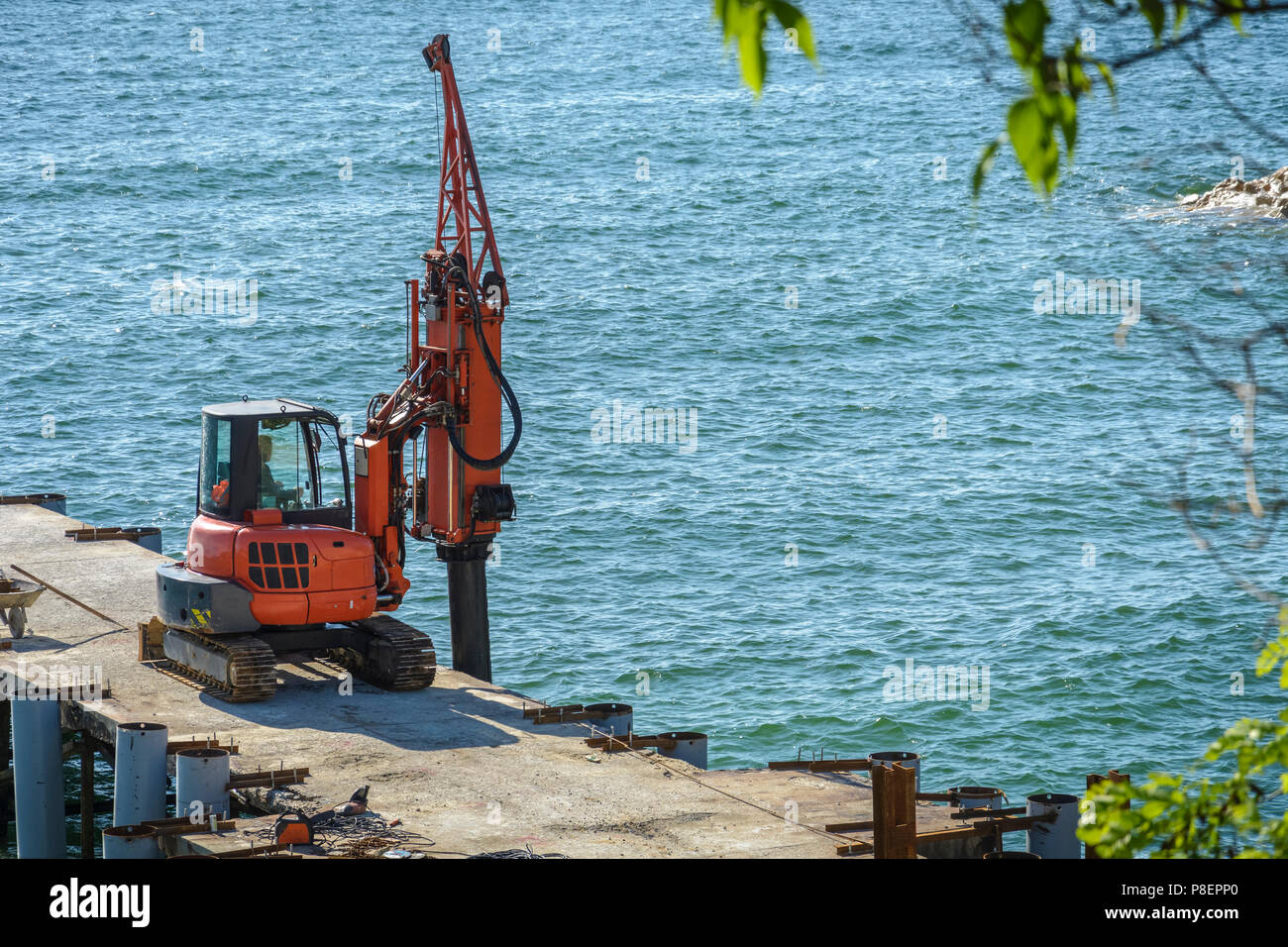 Drilling machine on a pier working, surrounded by water Stock Photo - Alamy