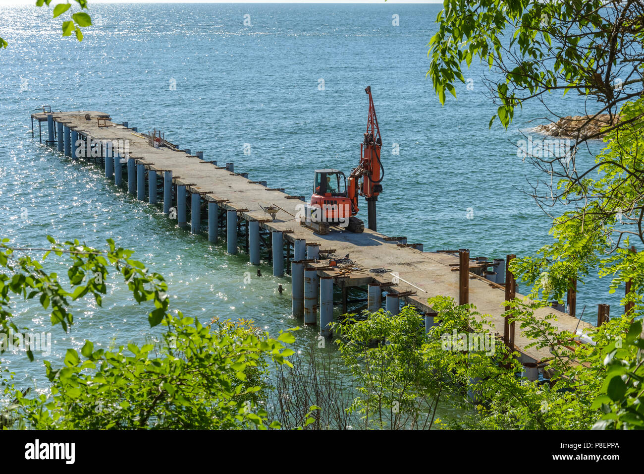 Drilling machine on a pier working, surrounded by water Stock Photo - Alamy