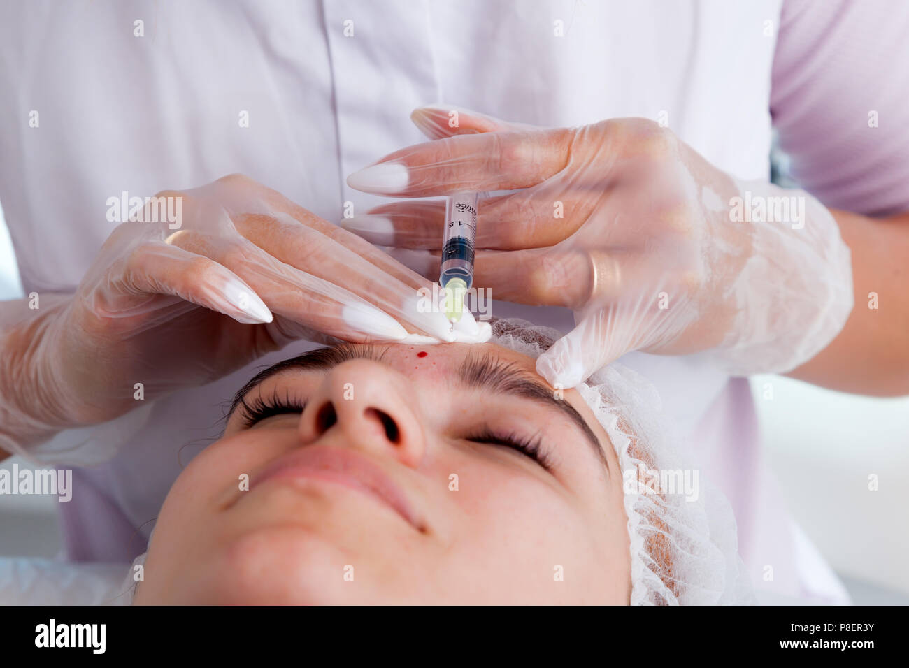 The doctor cosmetologist makes the Rejuvenating facial injections ...
