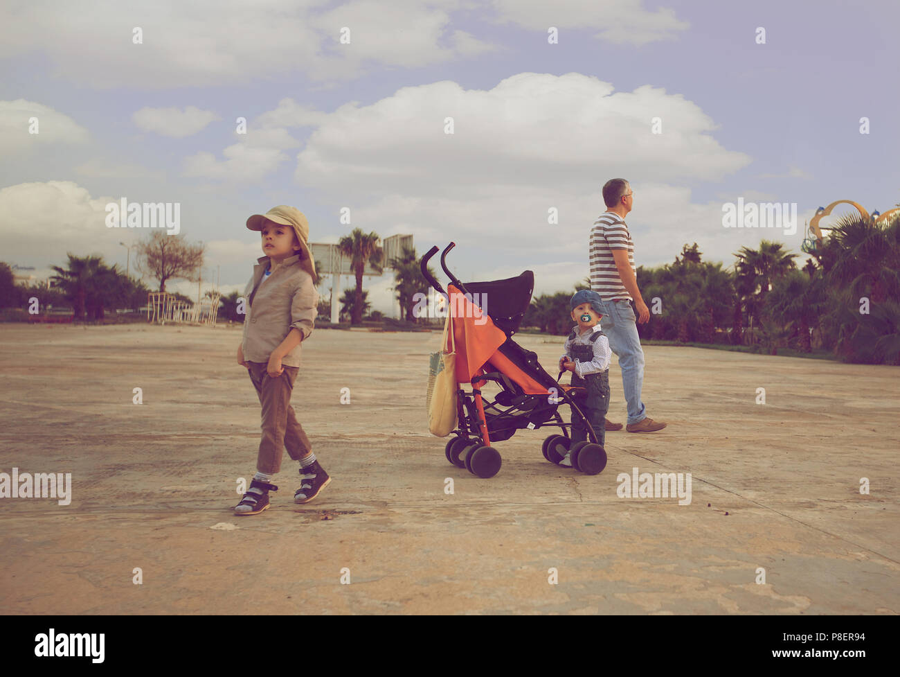 Father and two small sons are looking in three different directions ...