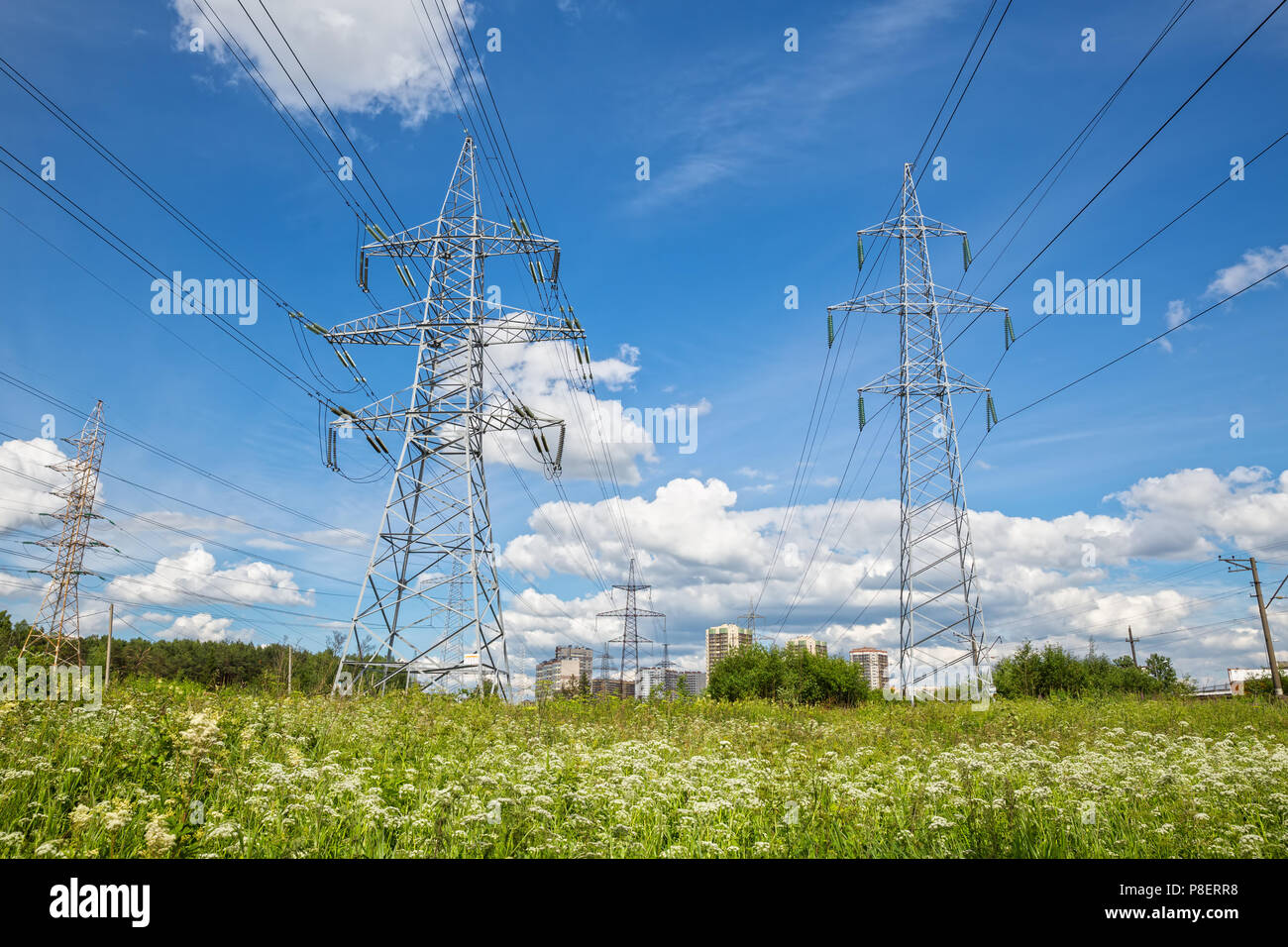 High-voltage power line passes through field to high-rise buildings of ...