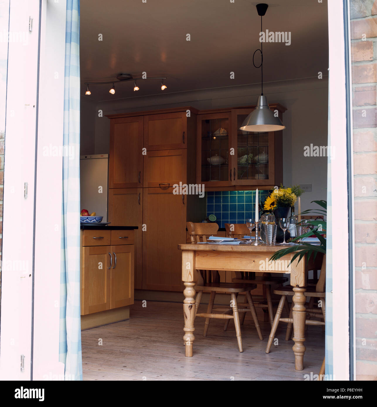 Looking through open door into kitchen with pine table and chairs Stock ...