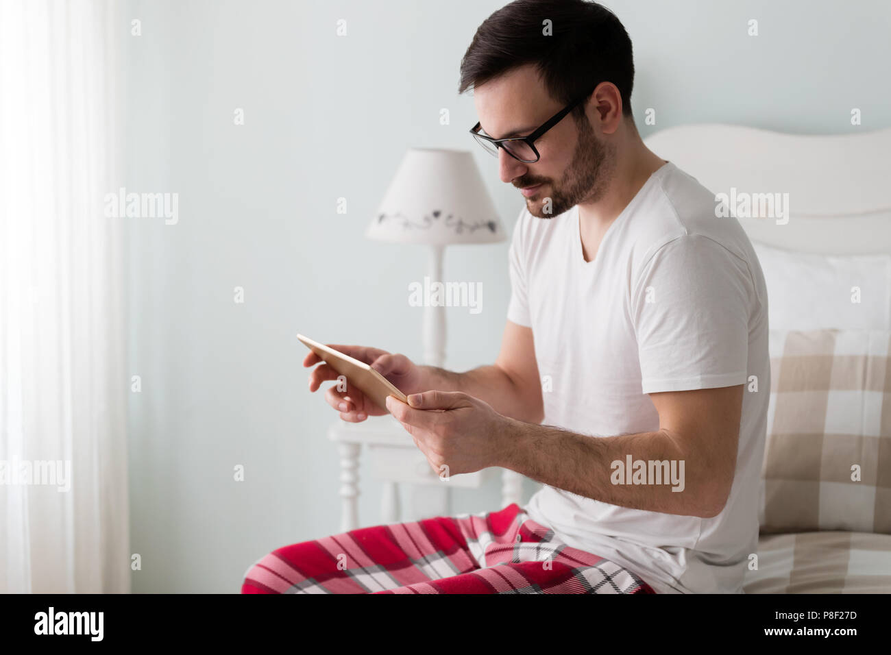 Young man in bedroom sitting hi-res stock photography and images - Alamy