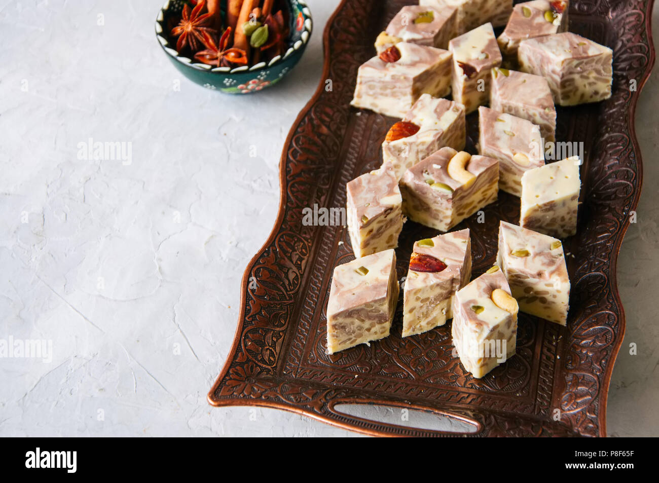 Traditional eastern dessert - halva with nuts and seeds served on a ...