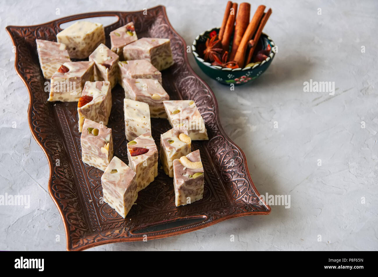 Traditional eastern dessert - halva with nuts and seeds served on a ...