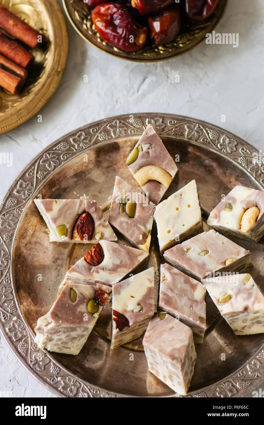 Traditional eastern dessert - halva with nuts and seeds served on a ...