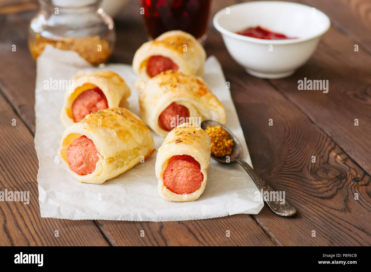 Pigs in a planket. Puff pastry rolls with sausages on a wooden ...