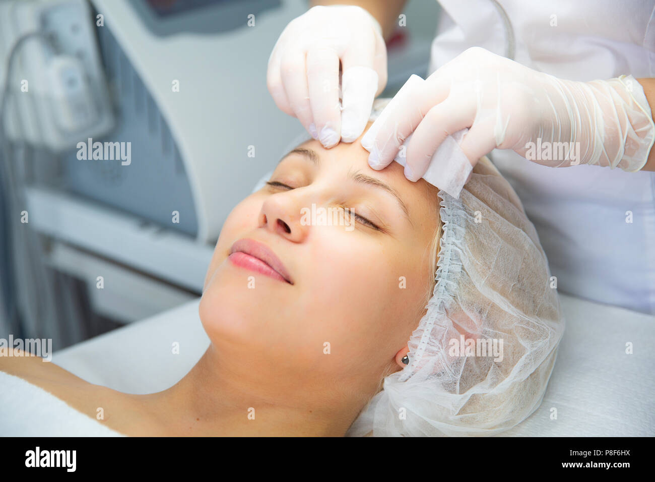 Cosmetologist removing facial mask from female face Stock Photo - Alamy