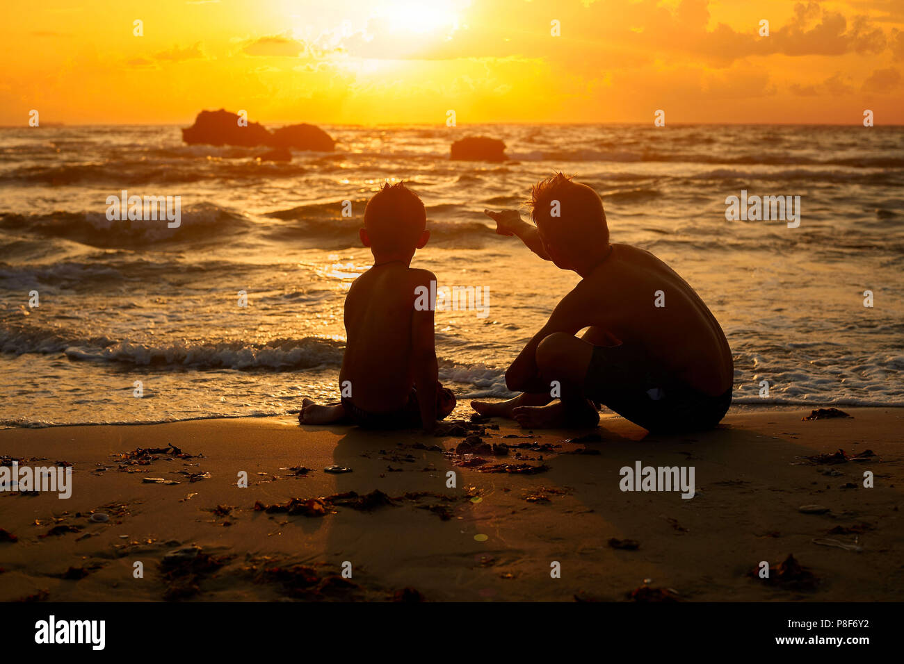 Family enjoying the sunlight on the rock hi-res stock photography and ...