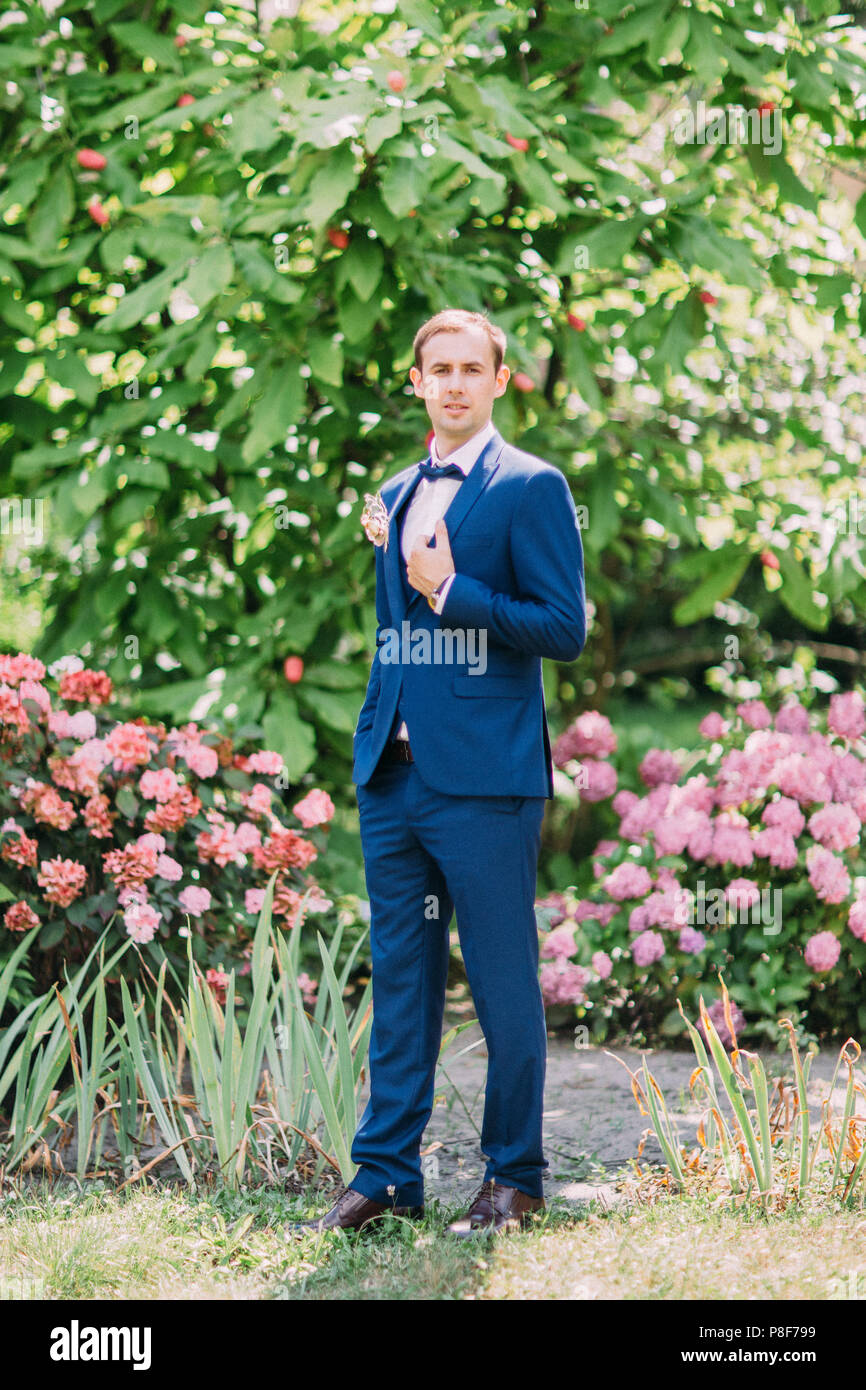 Full-length view of the groom in the beautiful garden Stock Photo - Alamy