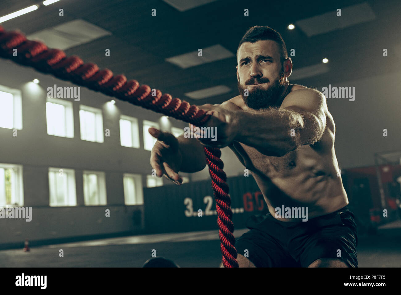 Men with battle rope battle ropes exercise in the fitness gym Stock ...