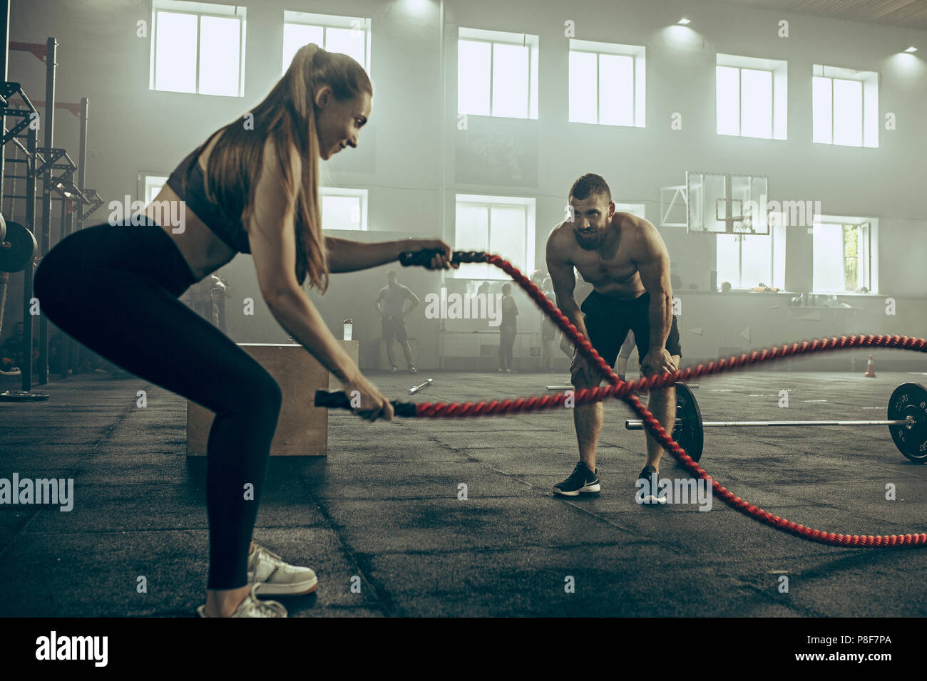 Woman with battle ropes exercise in the fitness gym Stock Photo - Alamy