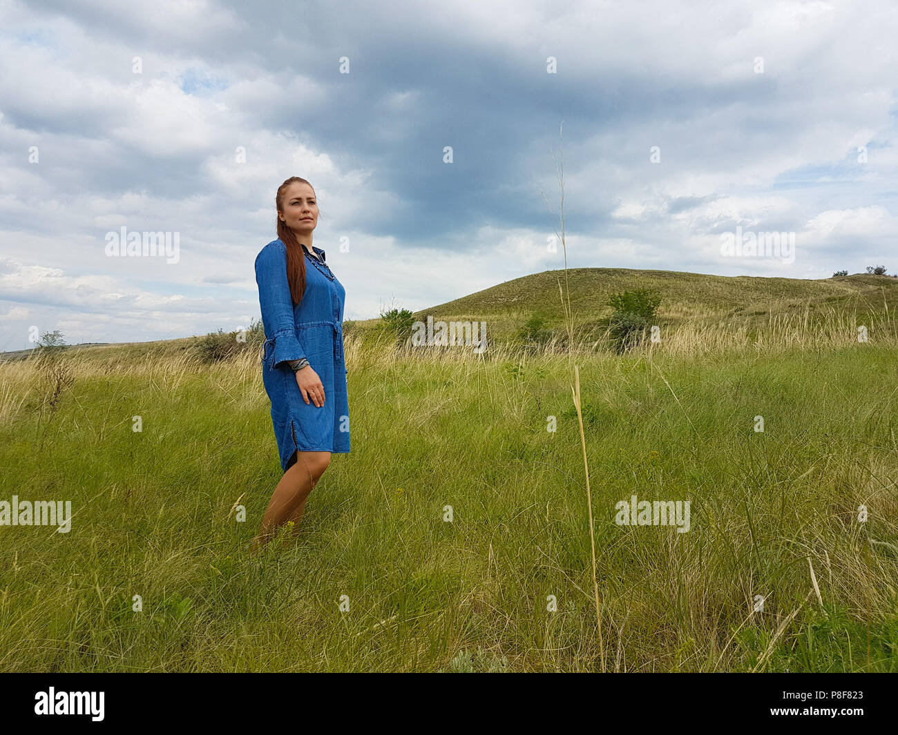woman walks in a sunny park and walks along the green grass. Summer ...