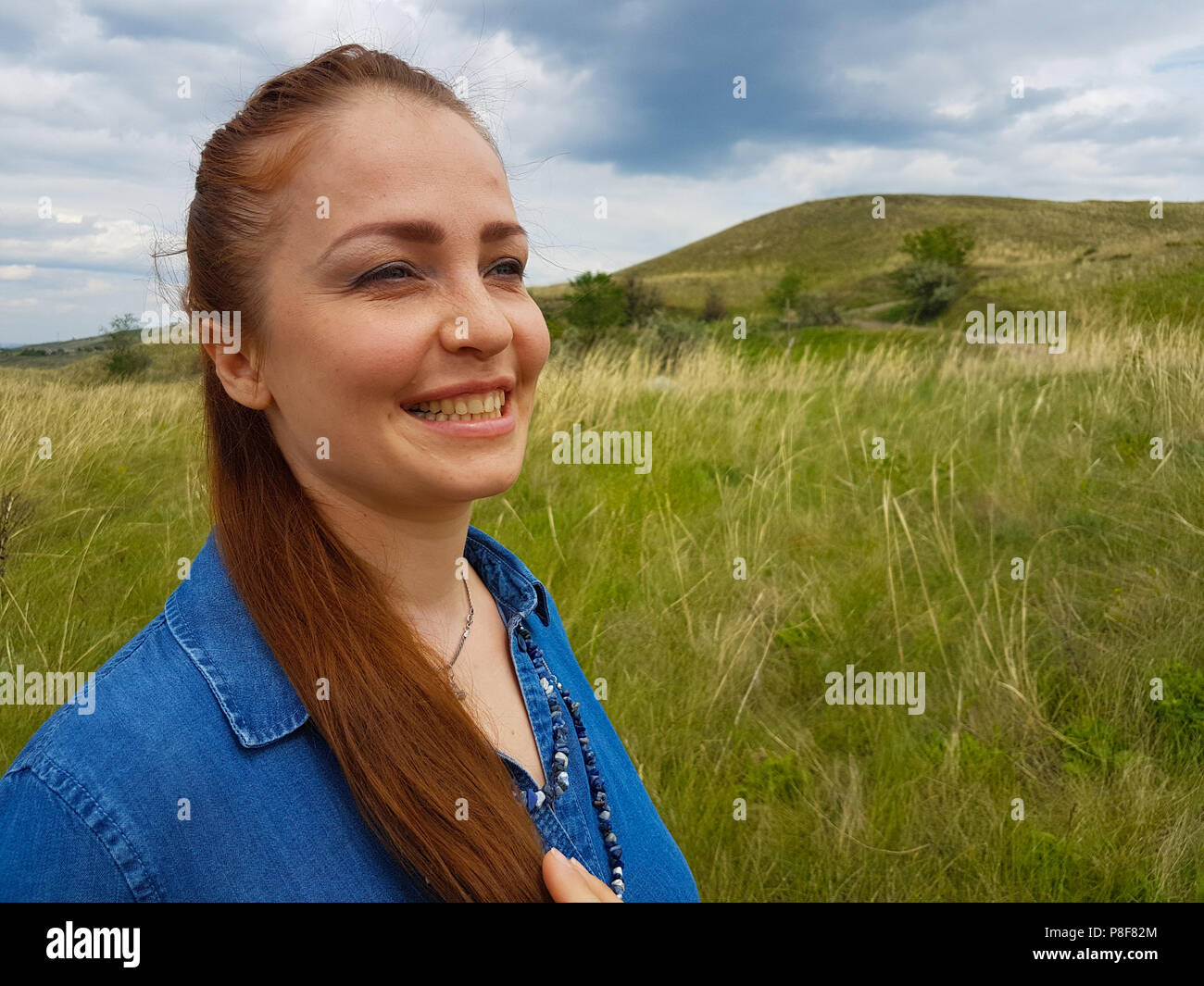 woman walks in a sunny park and walks along the green grass. Summer ...