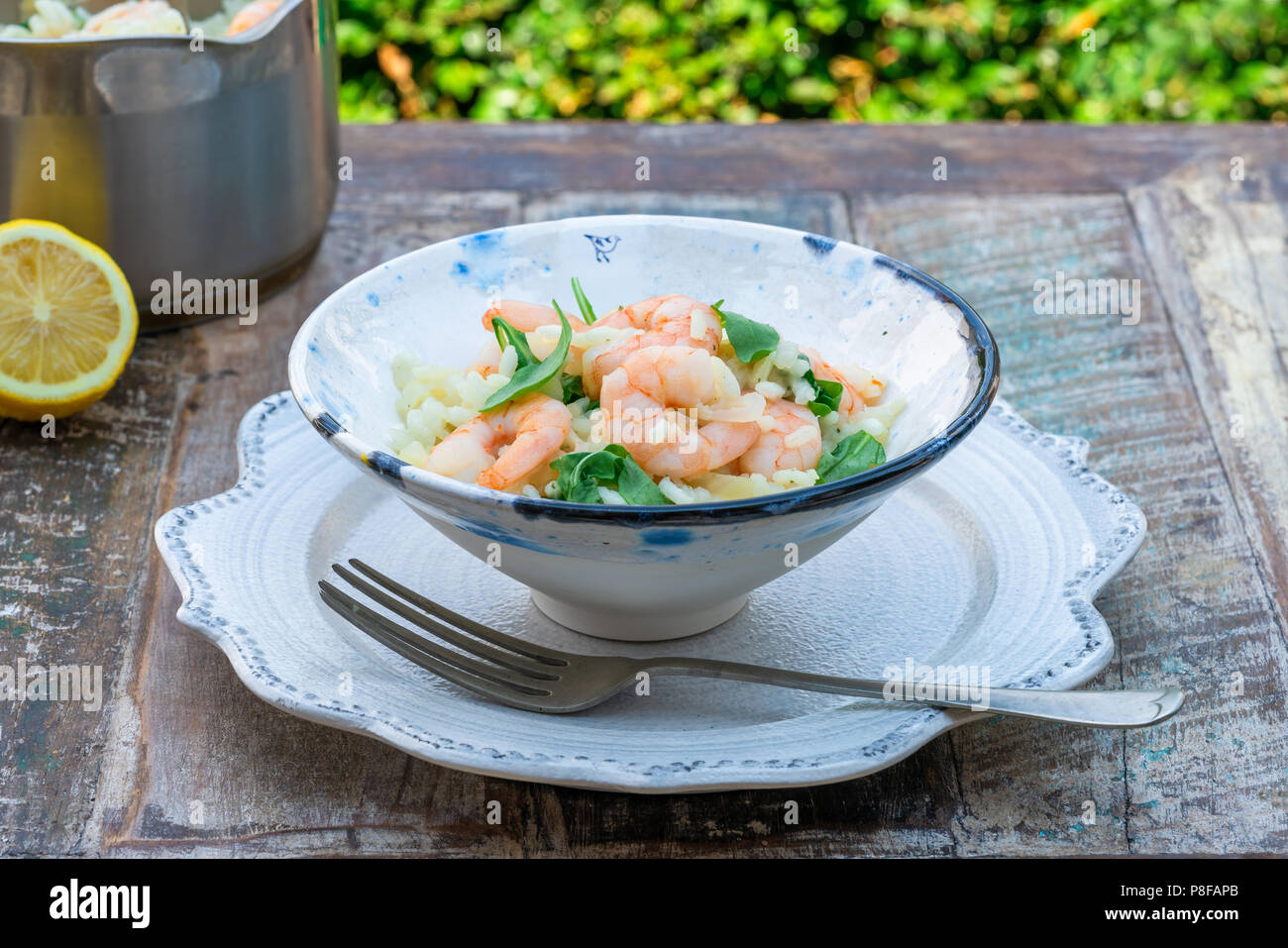 Prawn, fennel and rocket risotto on a table in the gargen. Outdoor ...