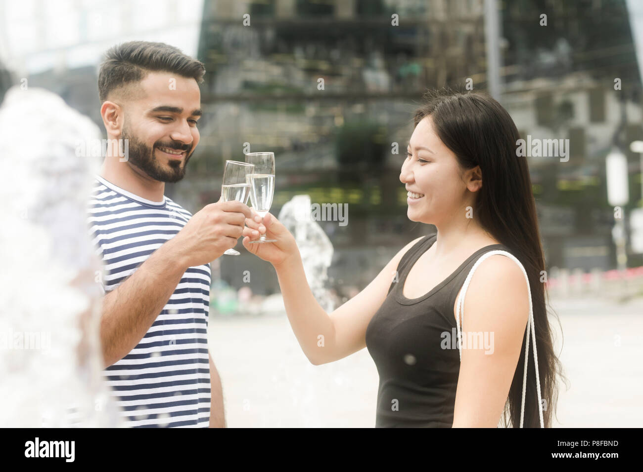 Couple standing by a water fountain making a celebratory toast Stock ...
