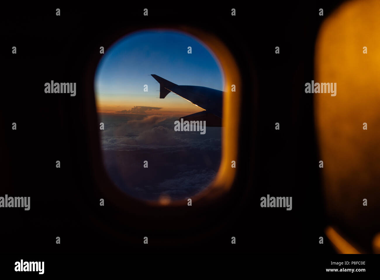 View of an airplane wing through the window at sunset Stock Photo - Alamy