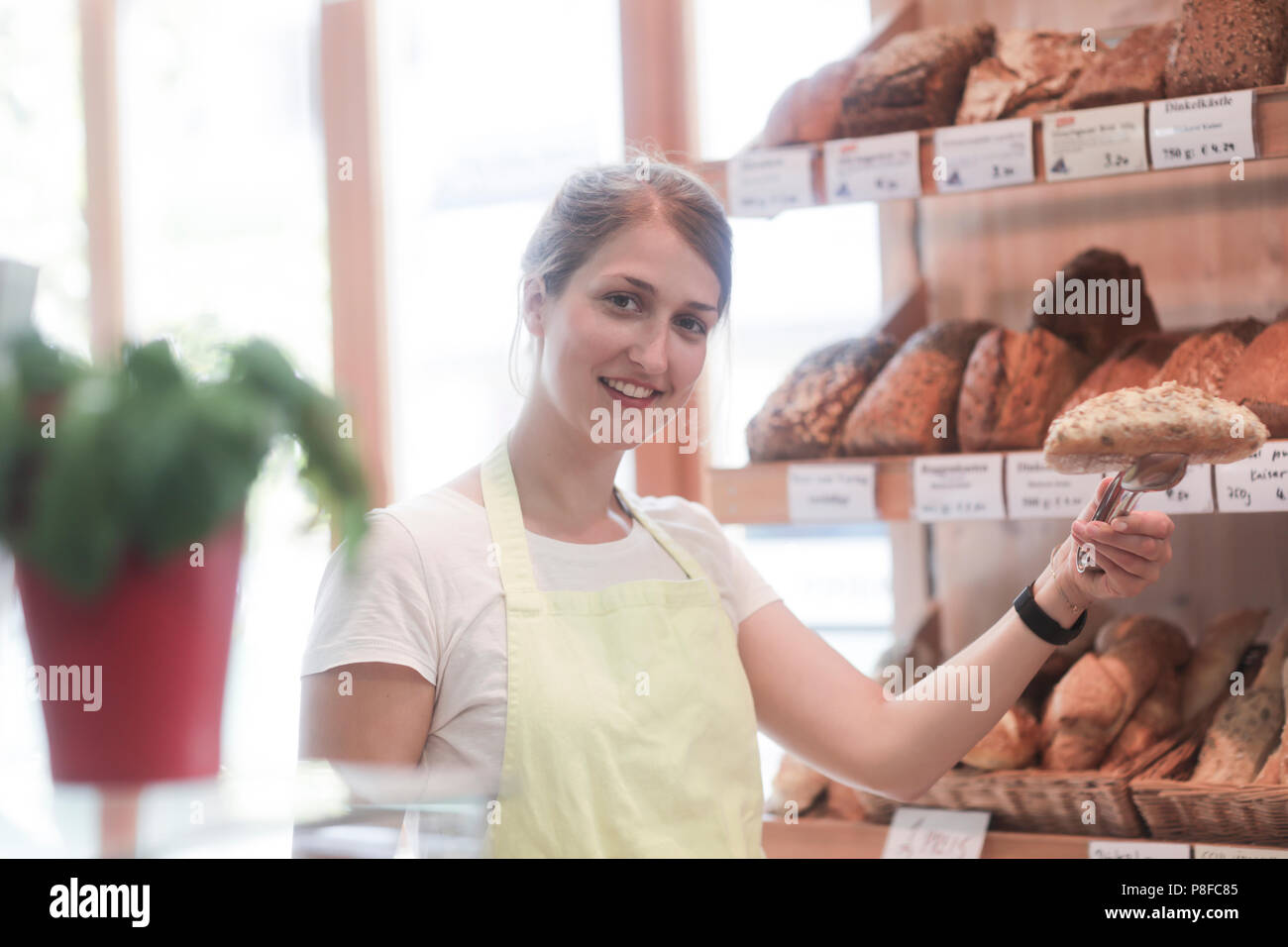 Smiling Sales assistant in a bakery Stock Photo - Alamy