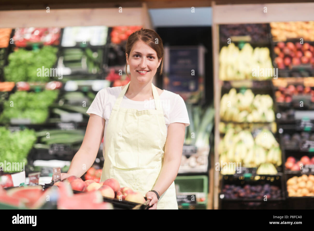 Portrait of a Smiling sales assistant standing in the fruit and ...