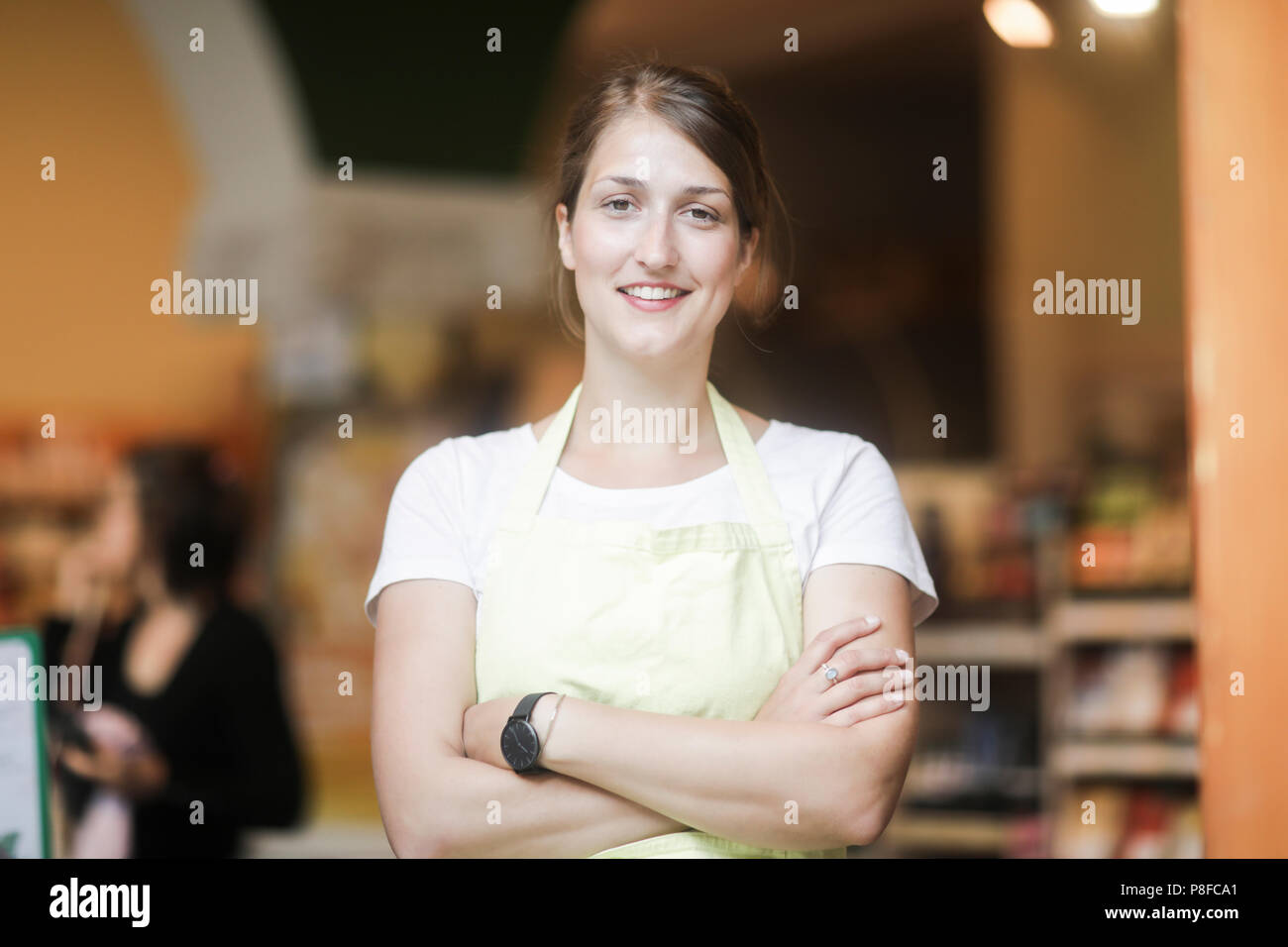 Portrait of a smiling sales assistant with her arms folded Stock Photo ...