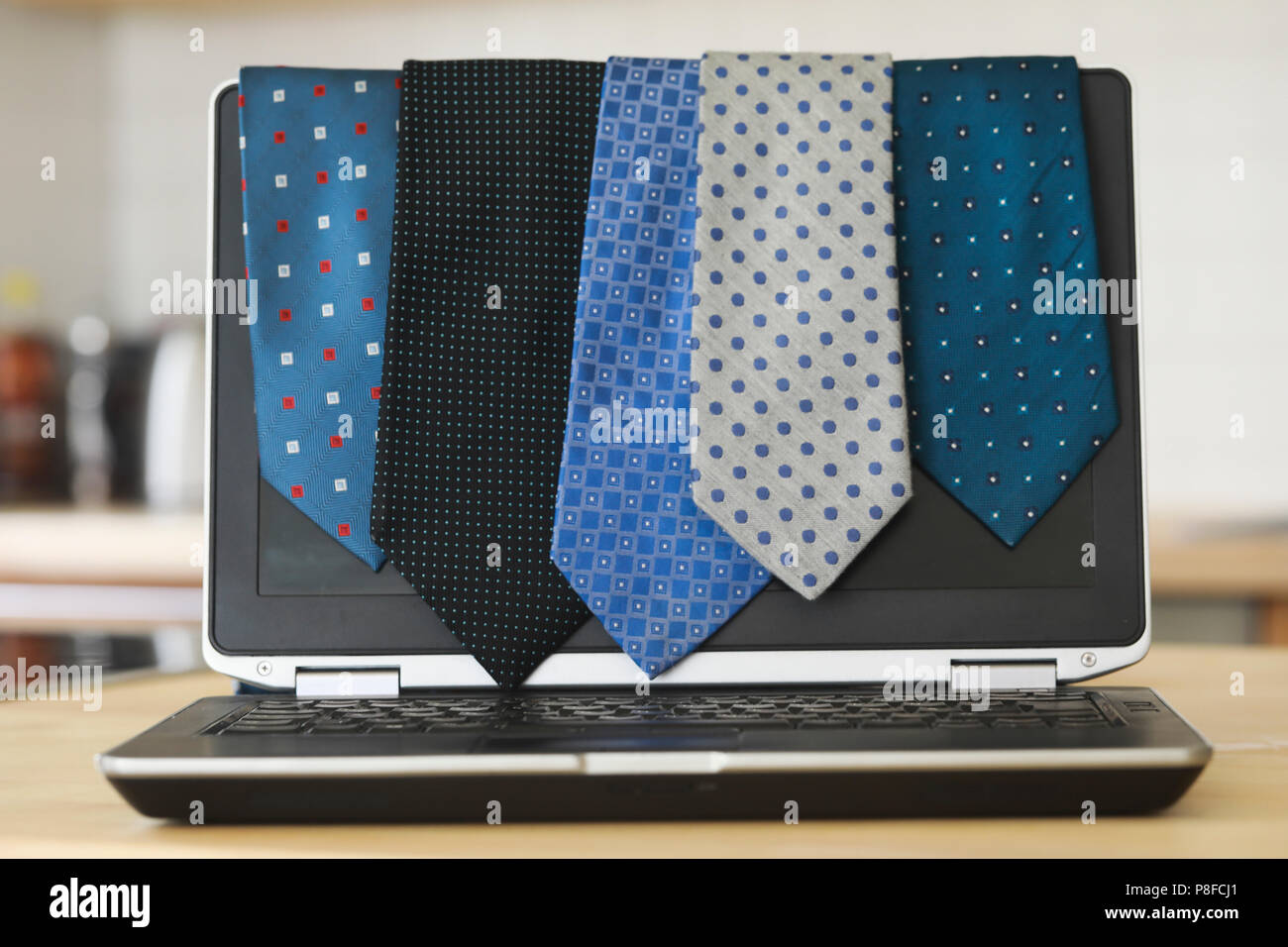 Five ties hanging on a laptop computer Stock Photo - Alamy
