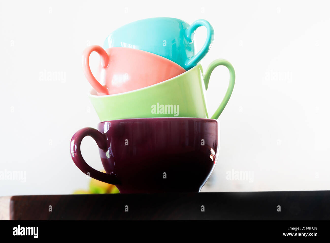 Stack of multi-colored mugs Stock Photo - Alamy