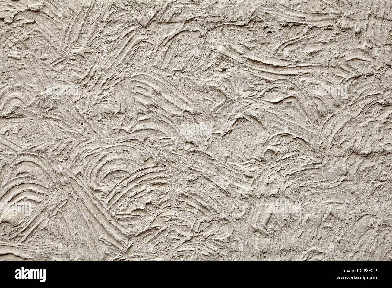Stucco wall with rough plaster and semicircular furrows, abstract ...
