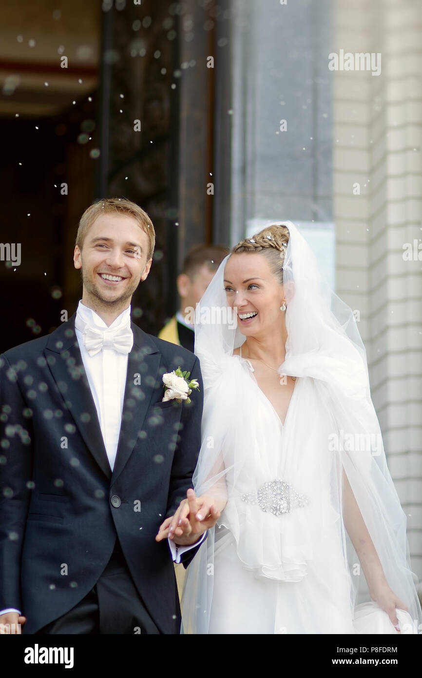 Happy just married couple under a rice rain Stock Photo - Alamy