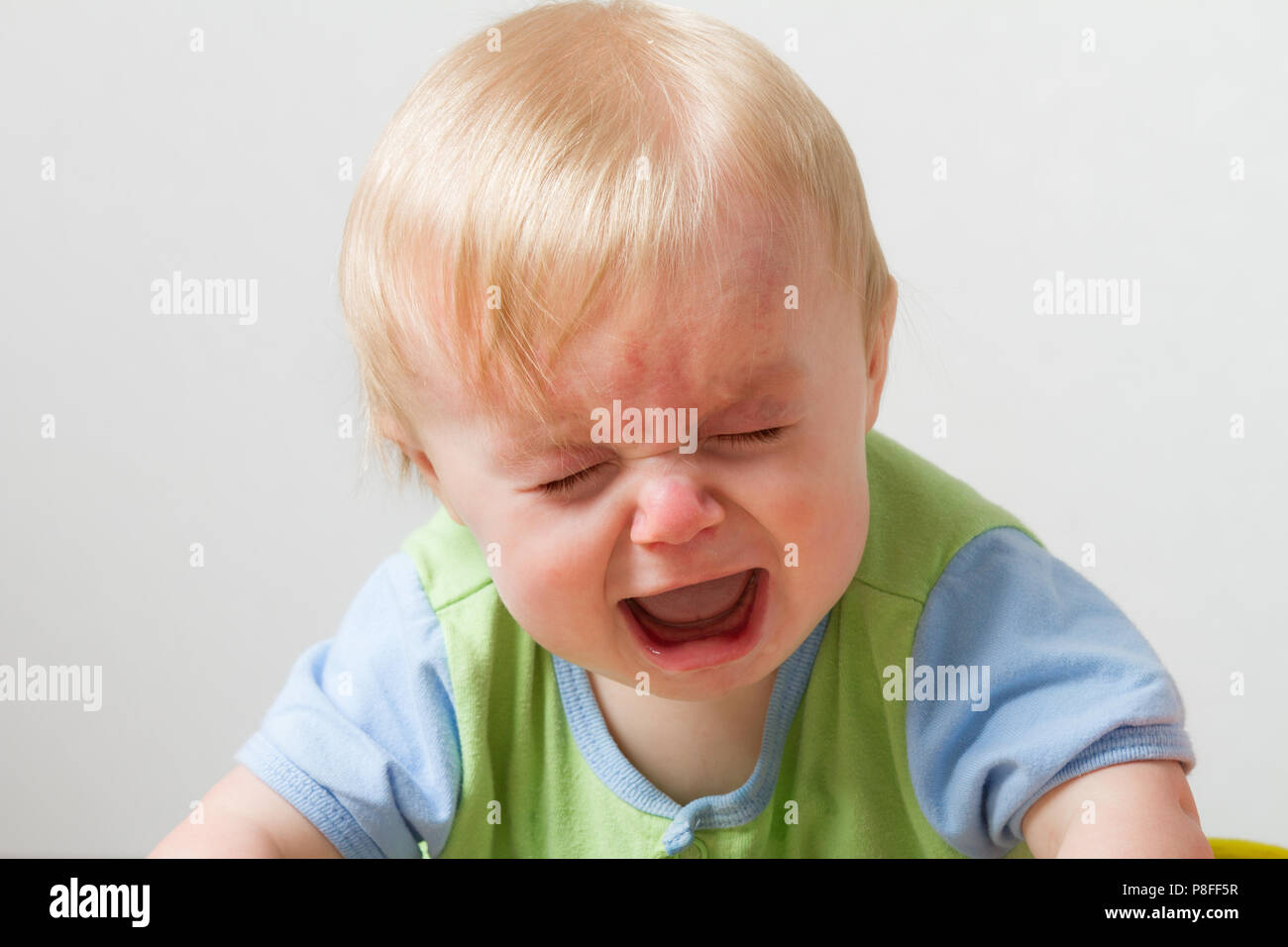 Young toddler crying away. Has his eyes closed and a huge open mouth ...