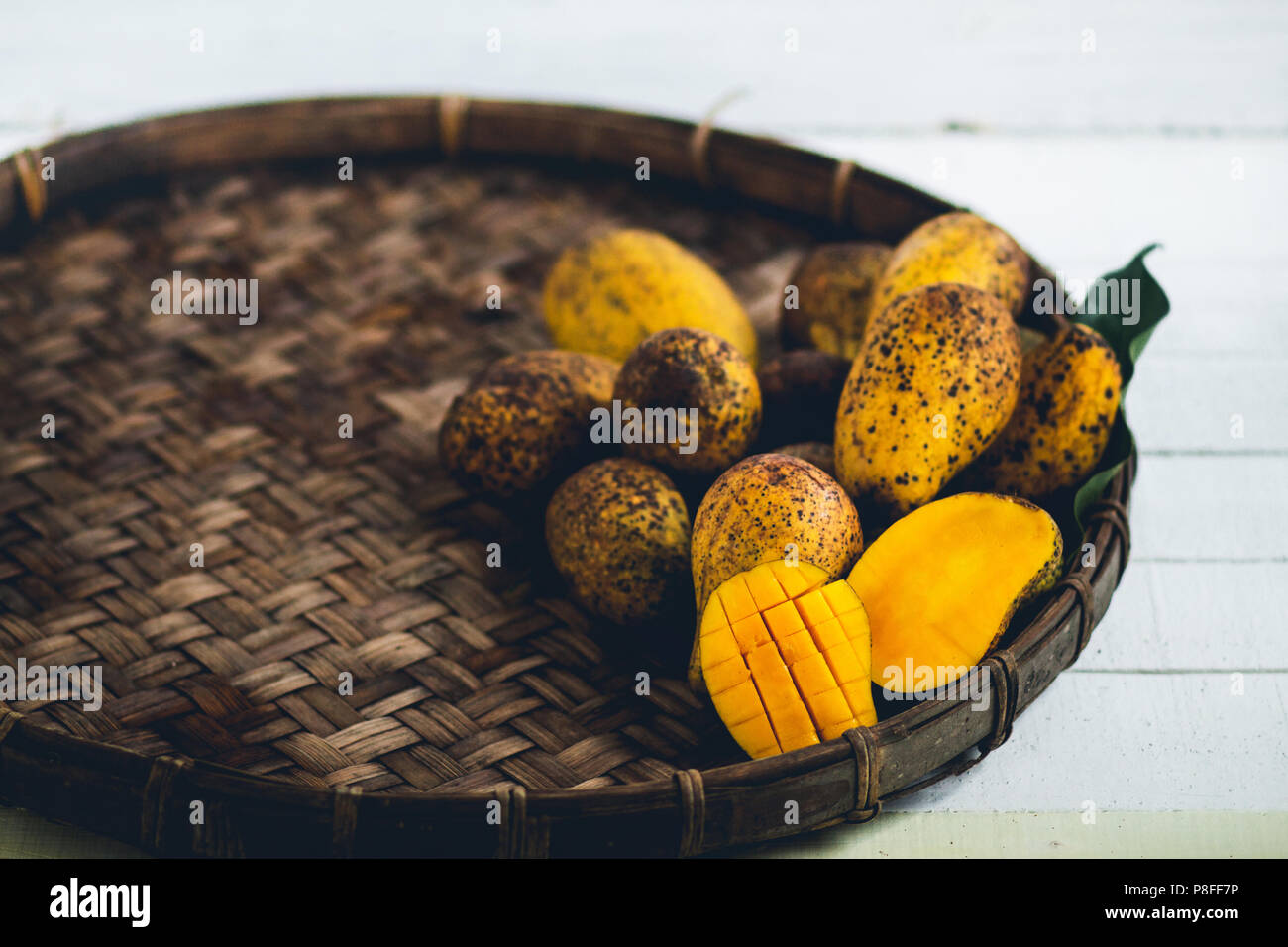 Nature mango In threshing basket On a wooden table and a white cloth ...