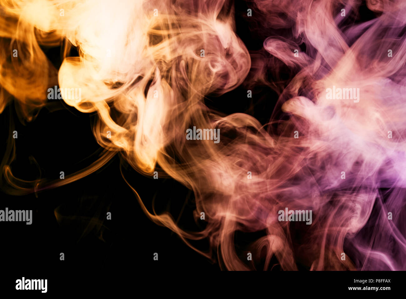 Thick colorful smoke of pink, orange on a black isolated background ...