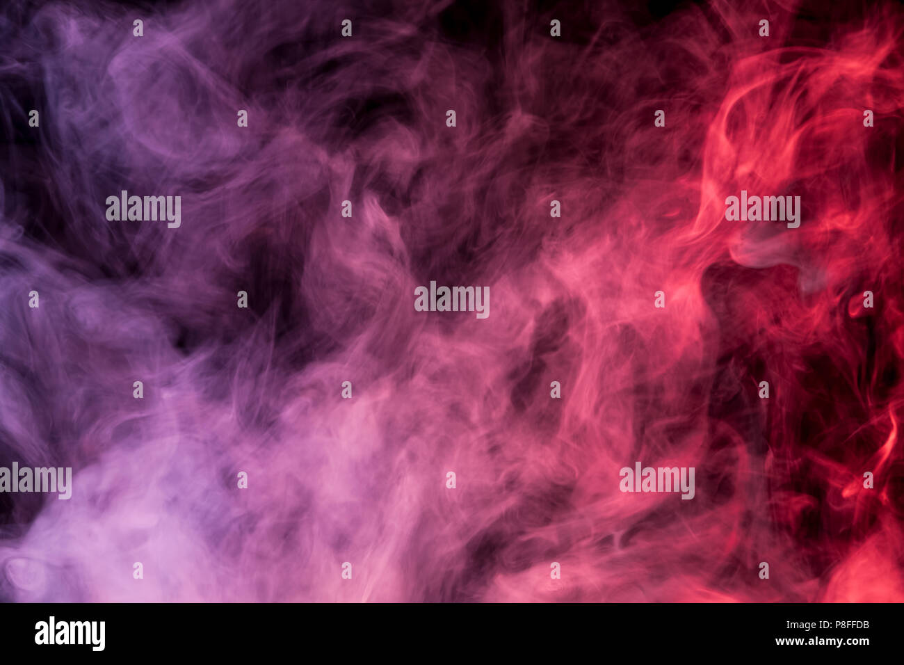 Dense multicolored smoke of pink, red and purple colors on a black ...
