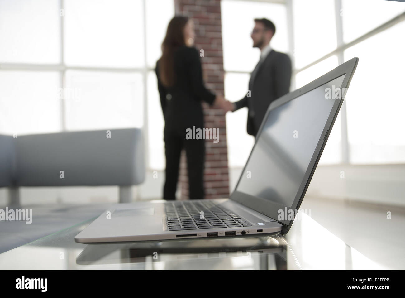 laptop on the desk, background handshake Stock Photo - Alamy