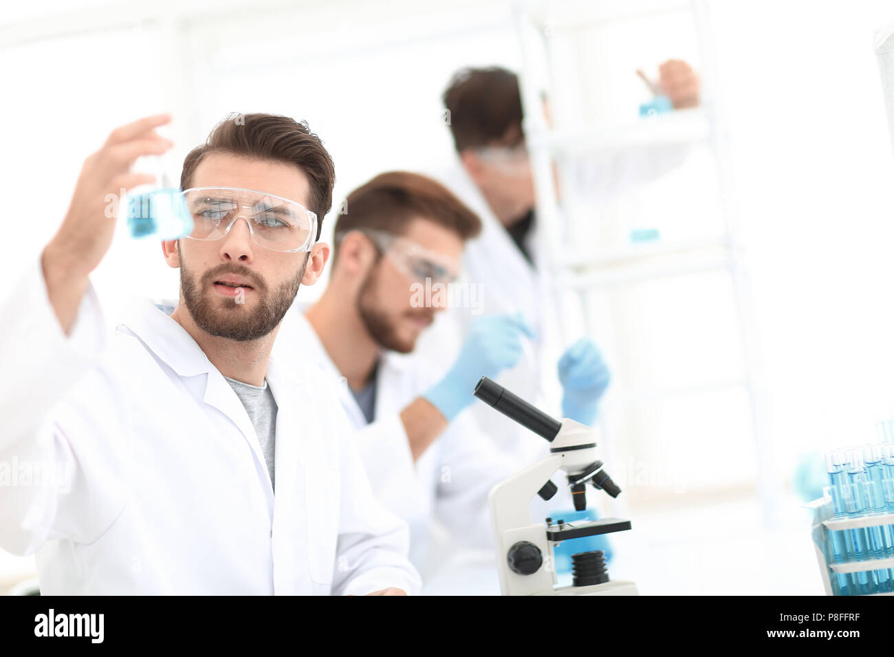 Scientists in lab looking beaker hi-res stock photography and images ...