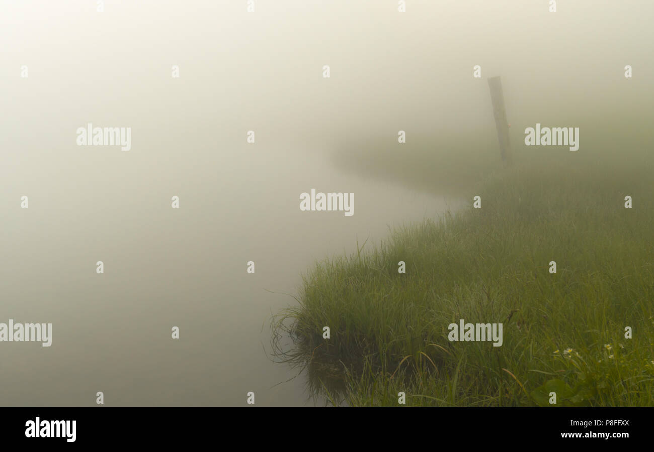 mountain lake and shore in thick fog Stock Photo - Alamy